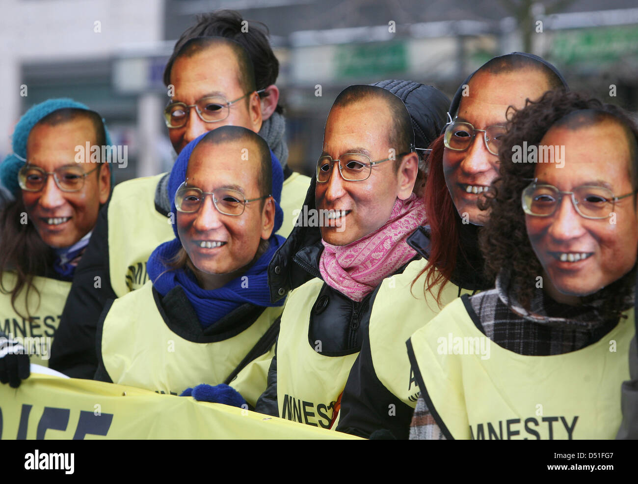 Activists of Amnesty International (ai) wear masks with the face of ...