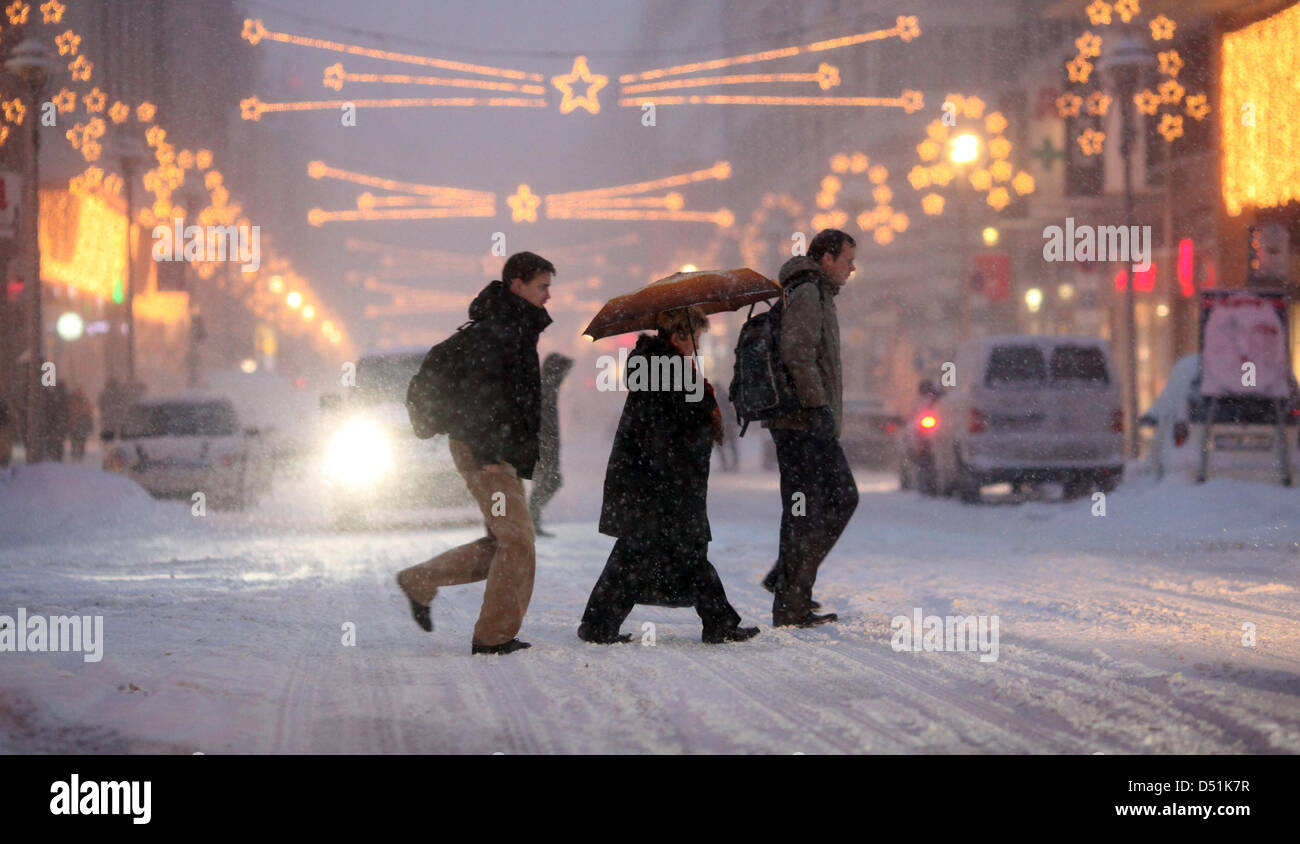 Passersby cross the snowy shopping street Friedrichstraße in Berlin ...