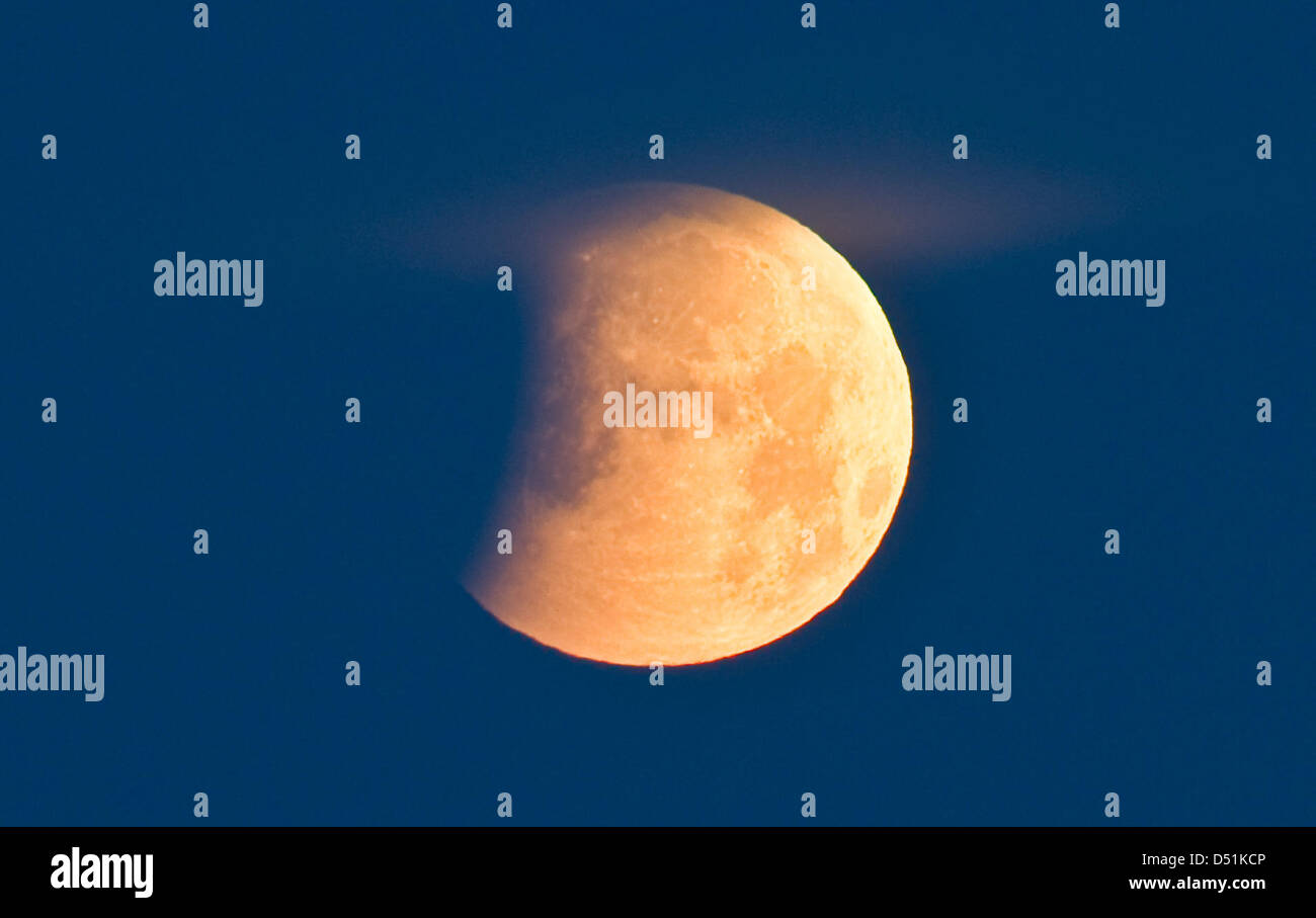 The umbral shadow of the earth appears in front of the full moon above ...