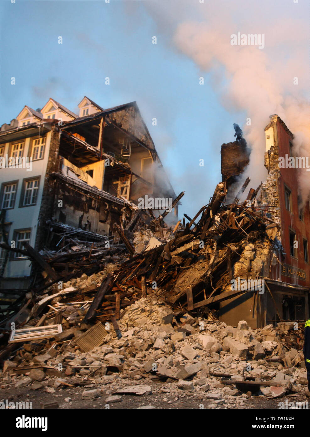 Smoke eminates from the collapsed ruins of a building after a fire in ...