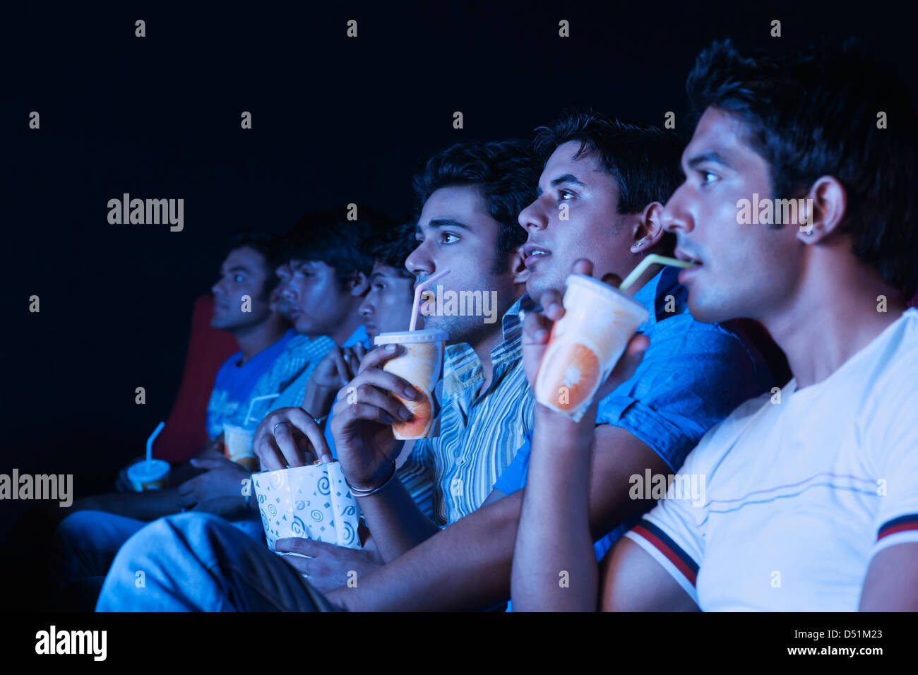 Youngsters enjoying movie in a cinema hall Stock Photo - Alamy
