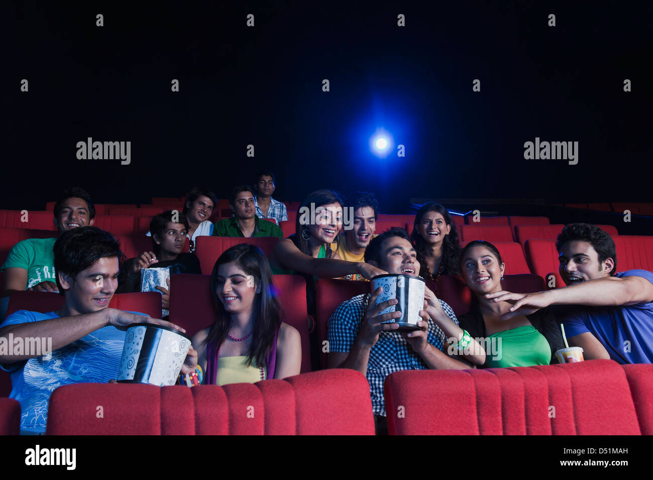 Youngsters enjoying movie in a cinema hall Stock Photo - Alamy