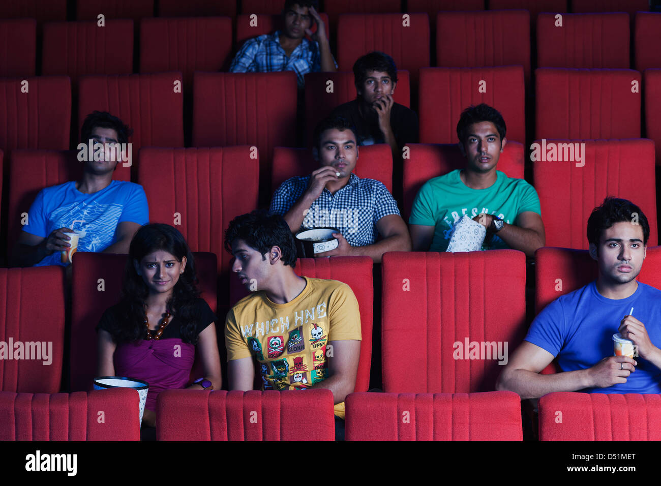 Youngsters enjoying movie in a cinema hall Stock Photo - Alamy