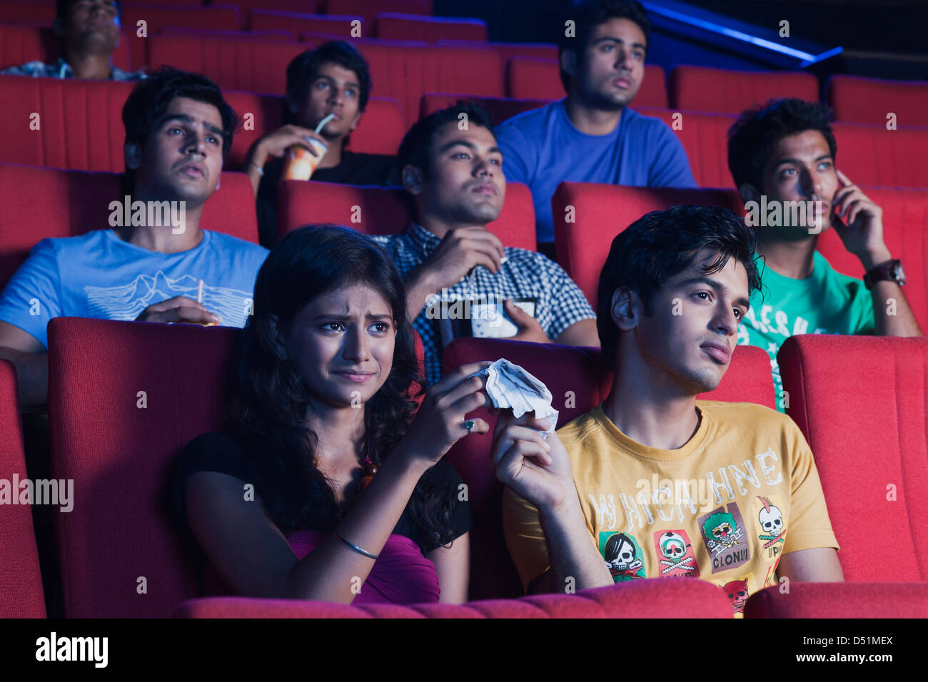 Youngsters enjoying movie in a cinema hall Stock Photo - Alamy