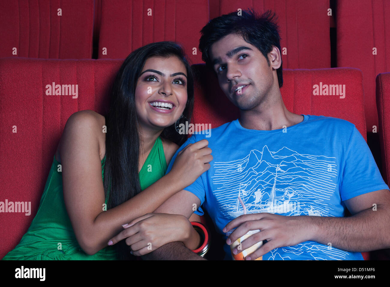 Couple enjoying movie in a cinema hall Stock Photo - Alamy