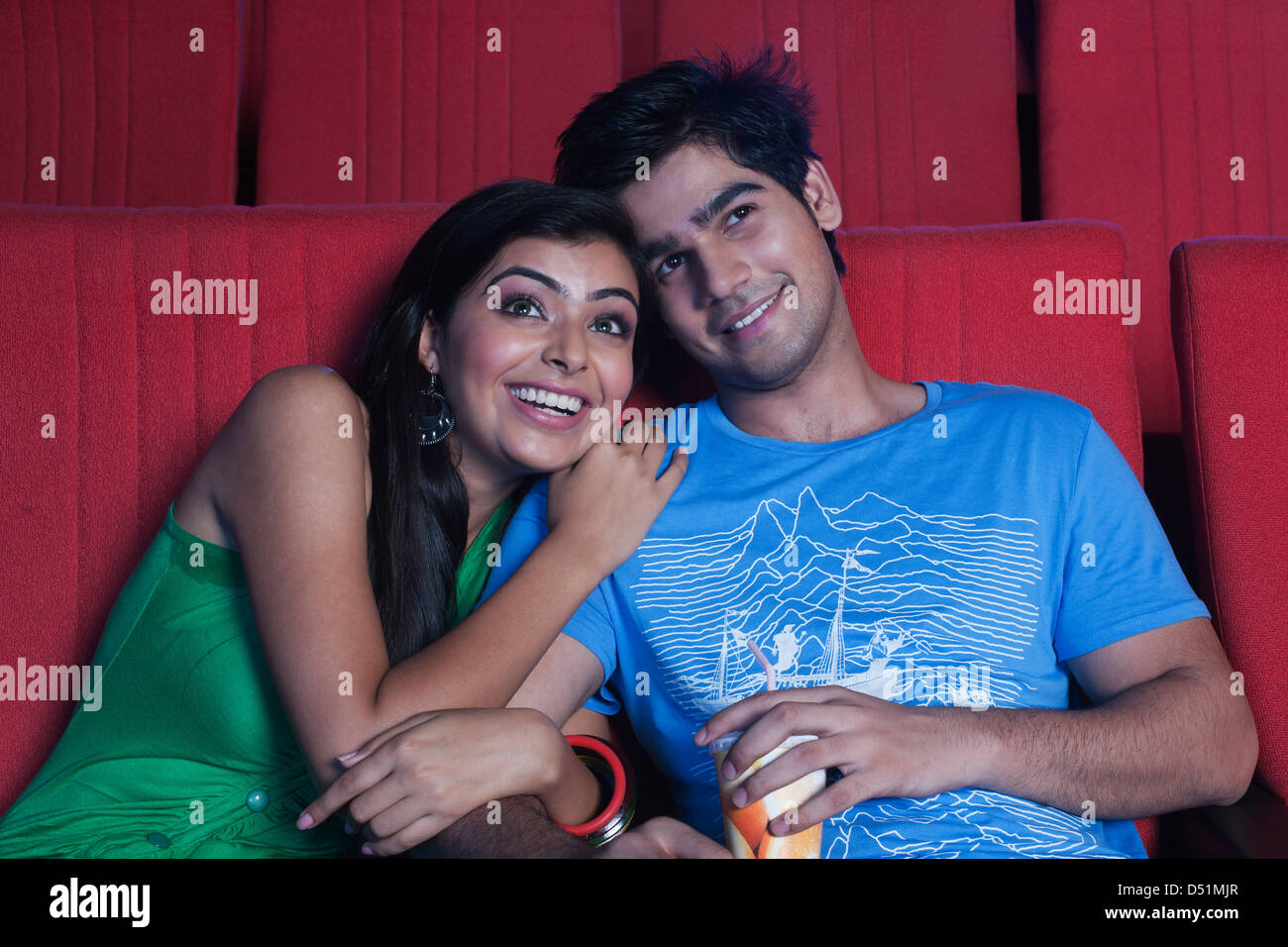Couple enjoying movie in a cinema hall Stock Photo - Alamy