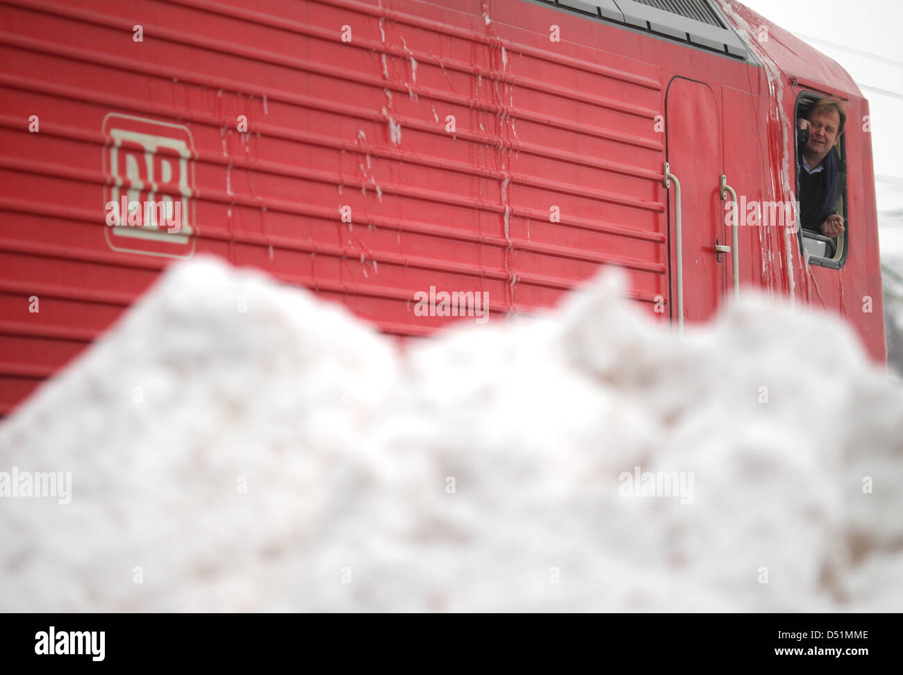 A regional train stands in mountains of snow at the central station of ...