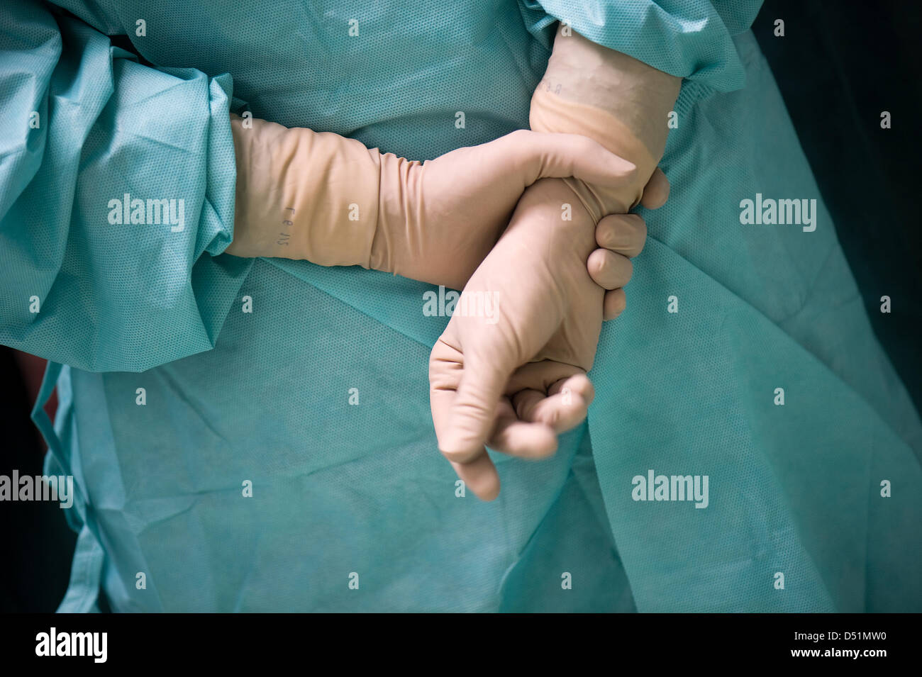 A doctor dressed in surgery clothes stands in an operating room at the ...