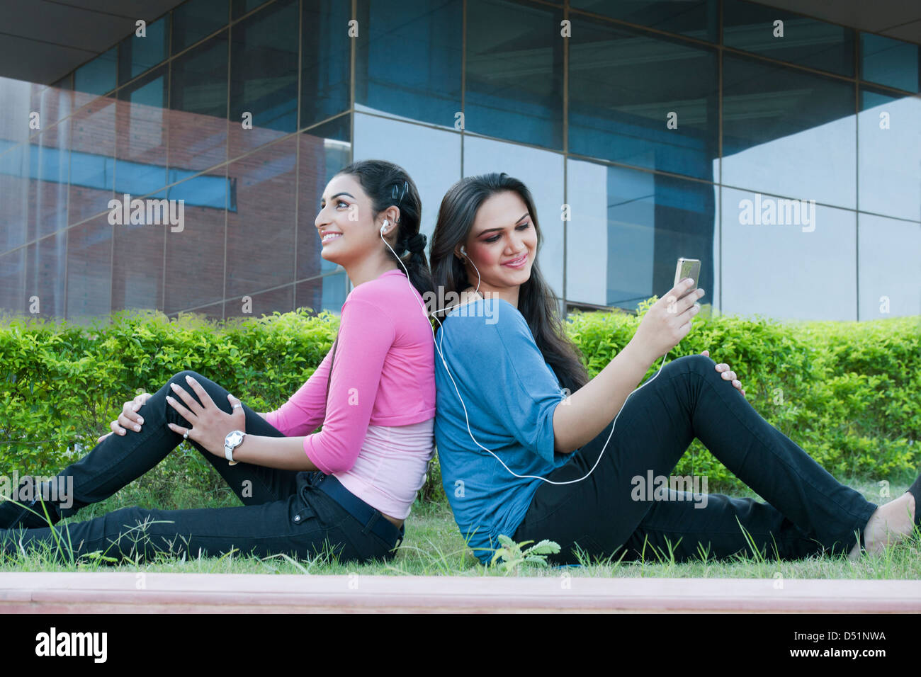 Female friends listening to music with a MP3 player Stock Photo - Alamy