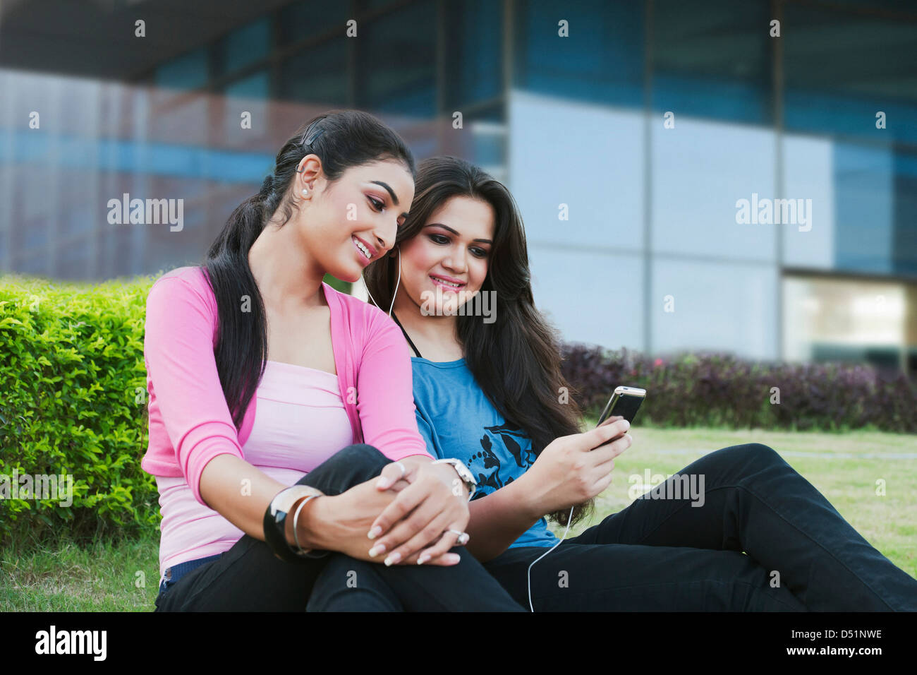 Female friends listening to music with a MP3 player Stock Photo - Alamy