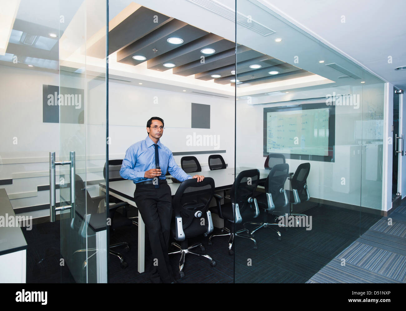Businessman standing in a conference room Stock Photo - Alamy