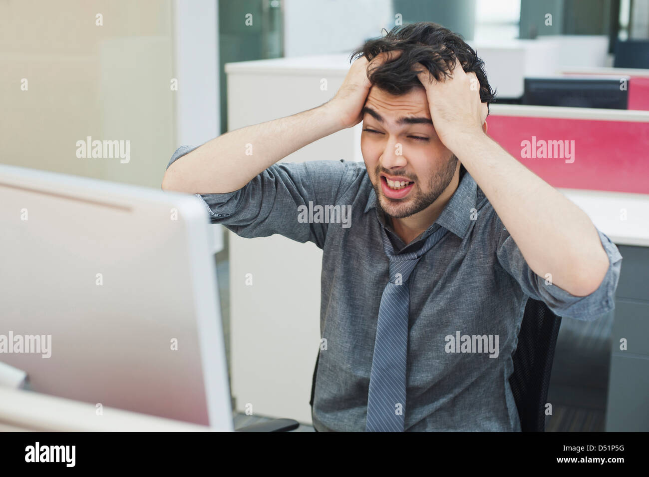 Upset businessman looking at a computer Stock Photo - Alamy