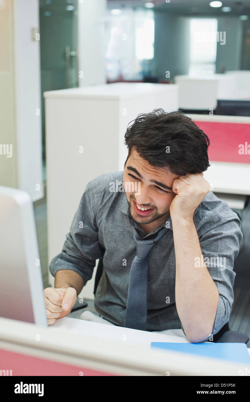 Upset businessman looking at a computer Stock Photo - Alamy