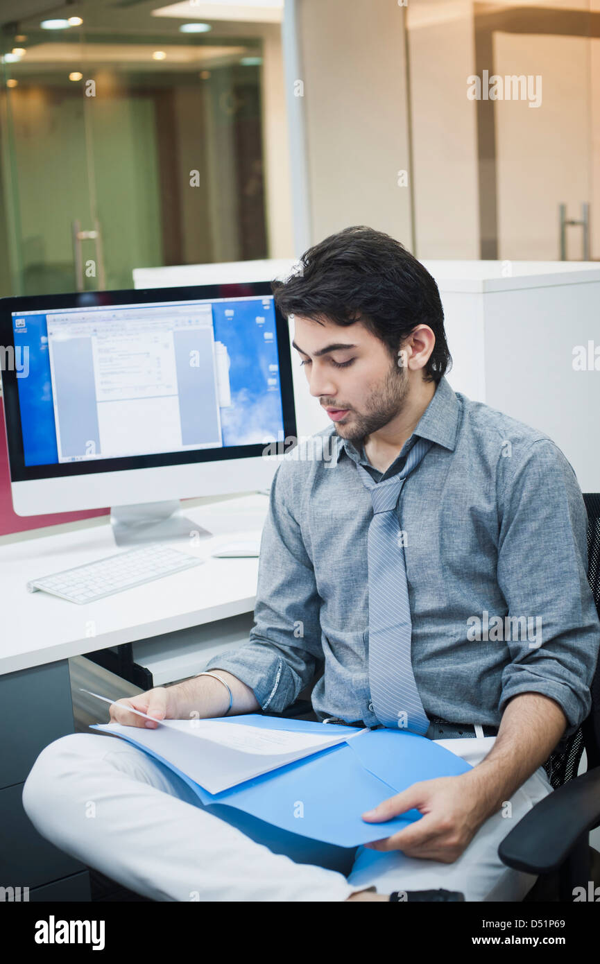 Businessman reading a document in office Stock Photo - Alamy
