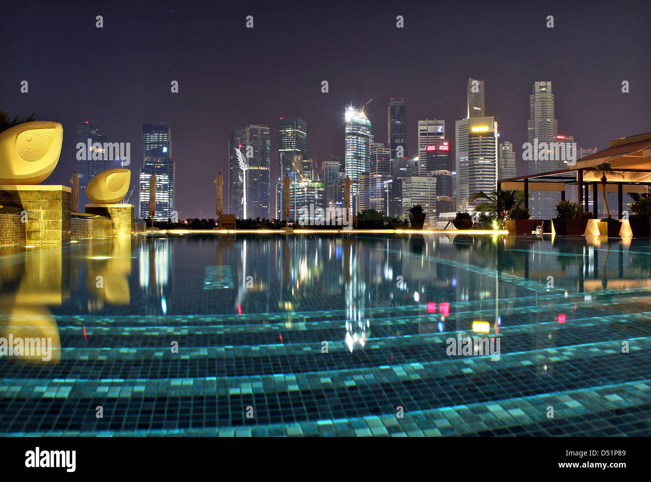 The skyline of Singapore mirrors on the water surface of a swimming ...