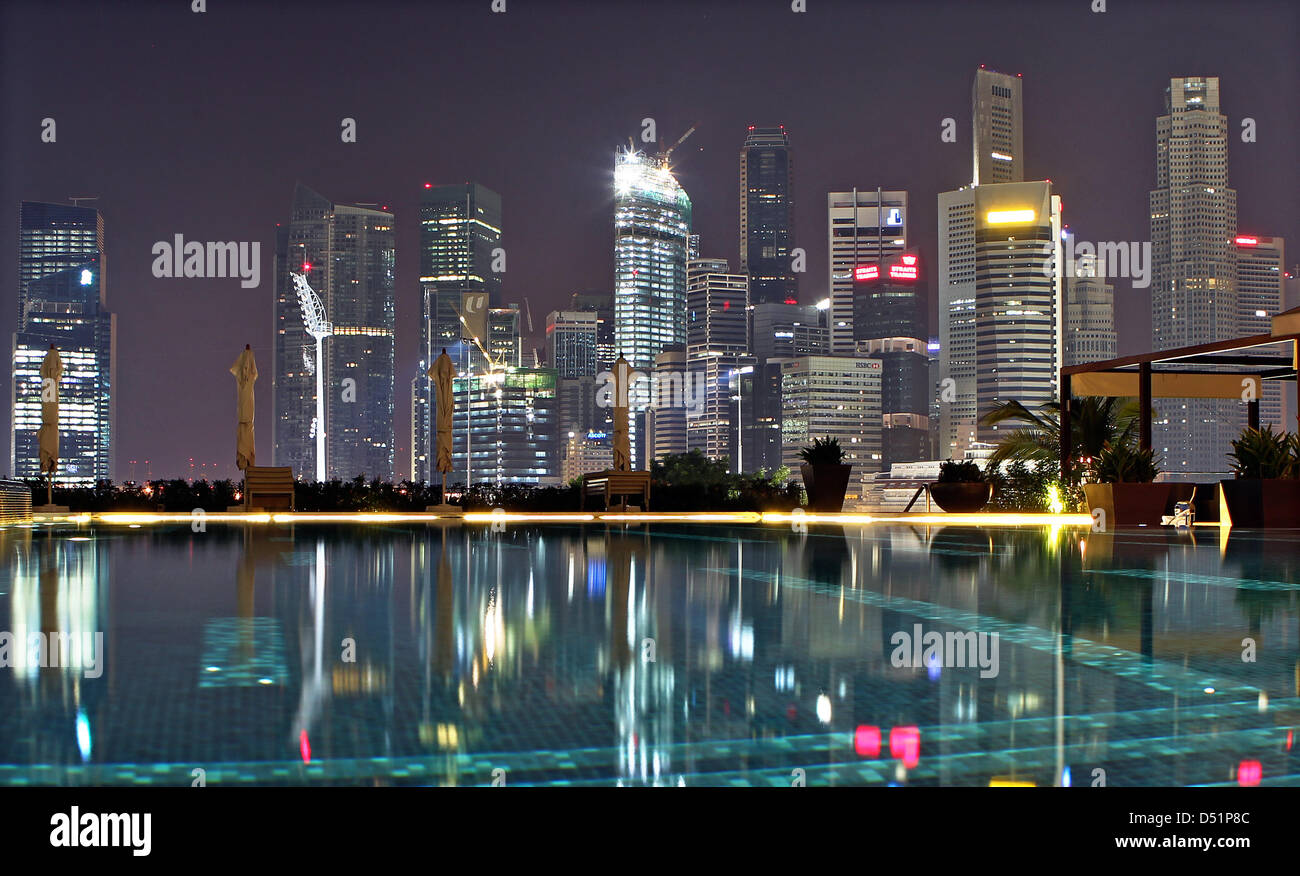 The skyline of Singapore mirrors on the water surface of a swimming ...