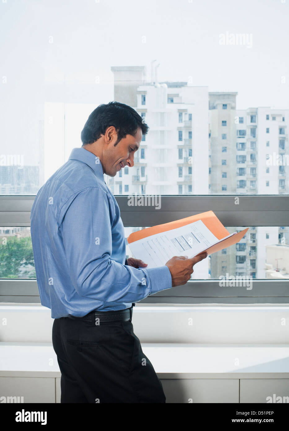 Businessman examining a file Stock Photo - Alamy