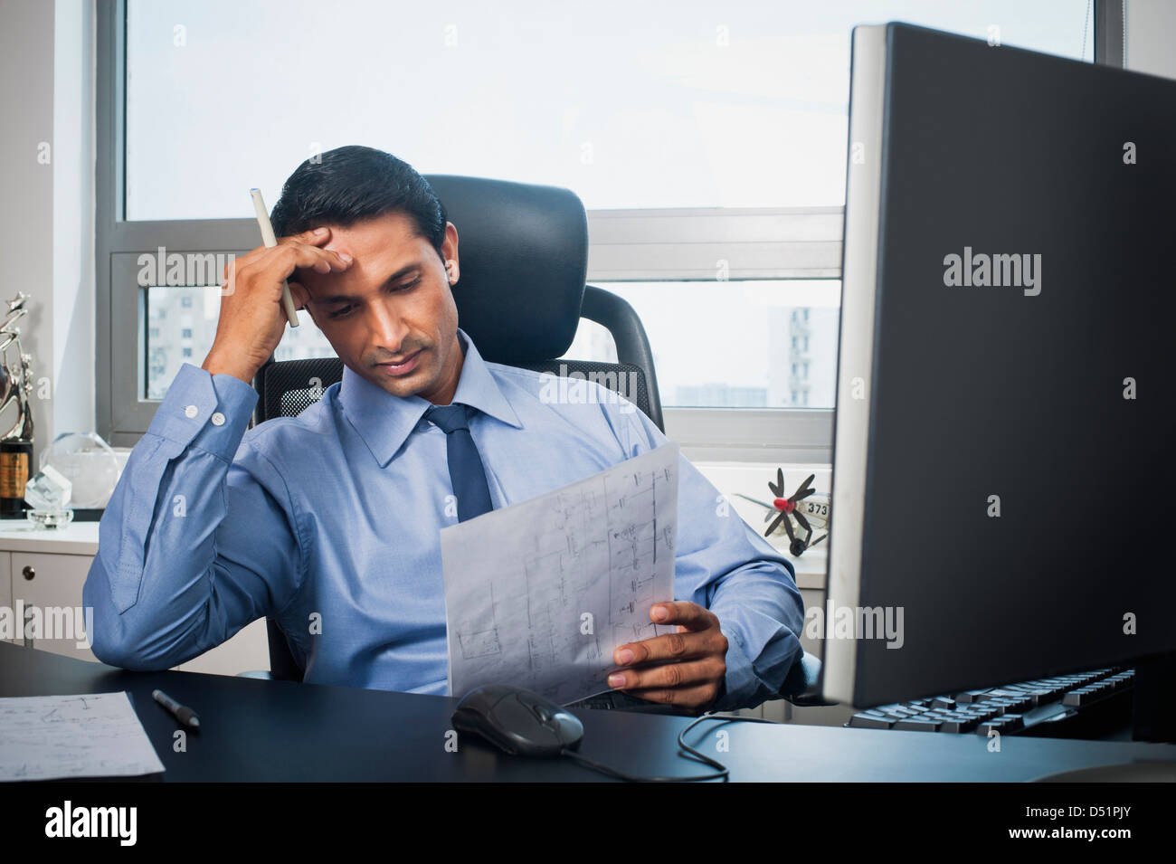 Businessman examining a document Stock Photo - Alamy