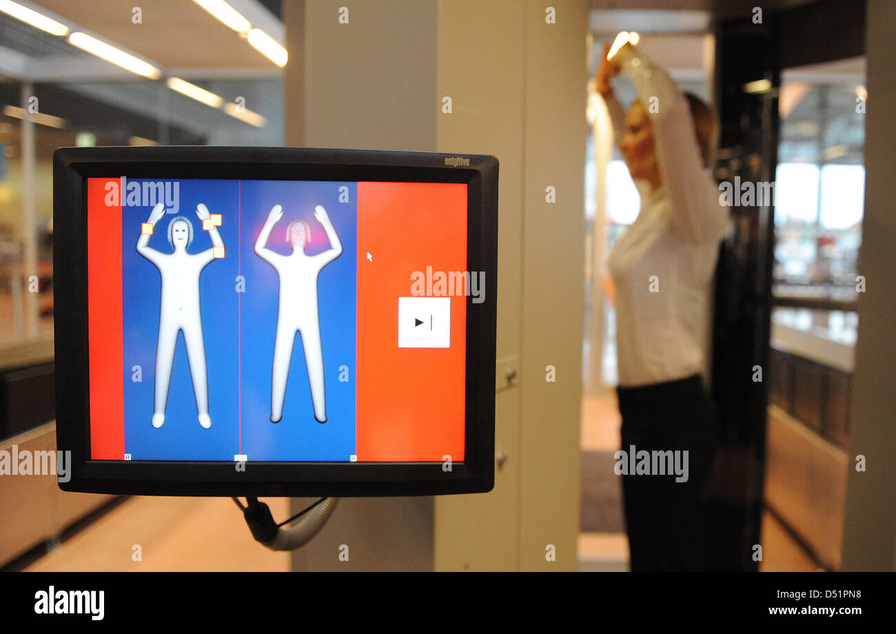 A woman stands inside a body scanner at the airport in Hamburg, Germany ...