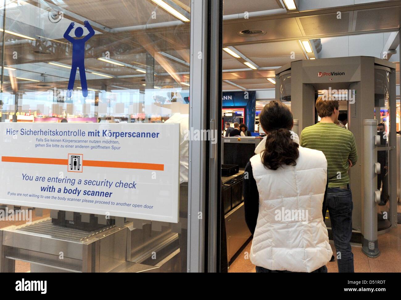 People queue at a security check with body scanners at the airport in ...