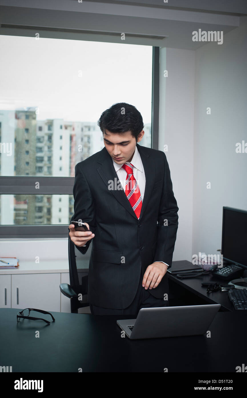 Businessman using a mobile phone in office Stock Photo - Alamy