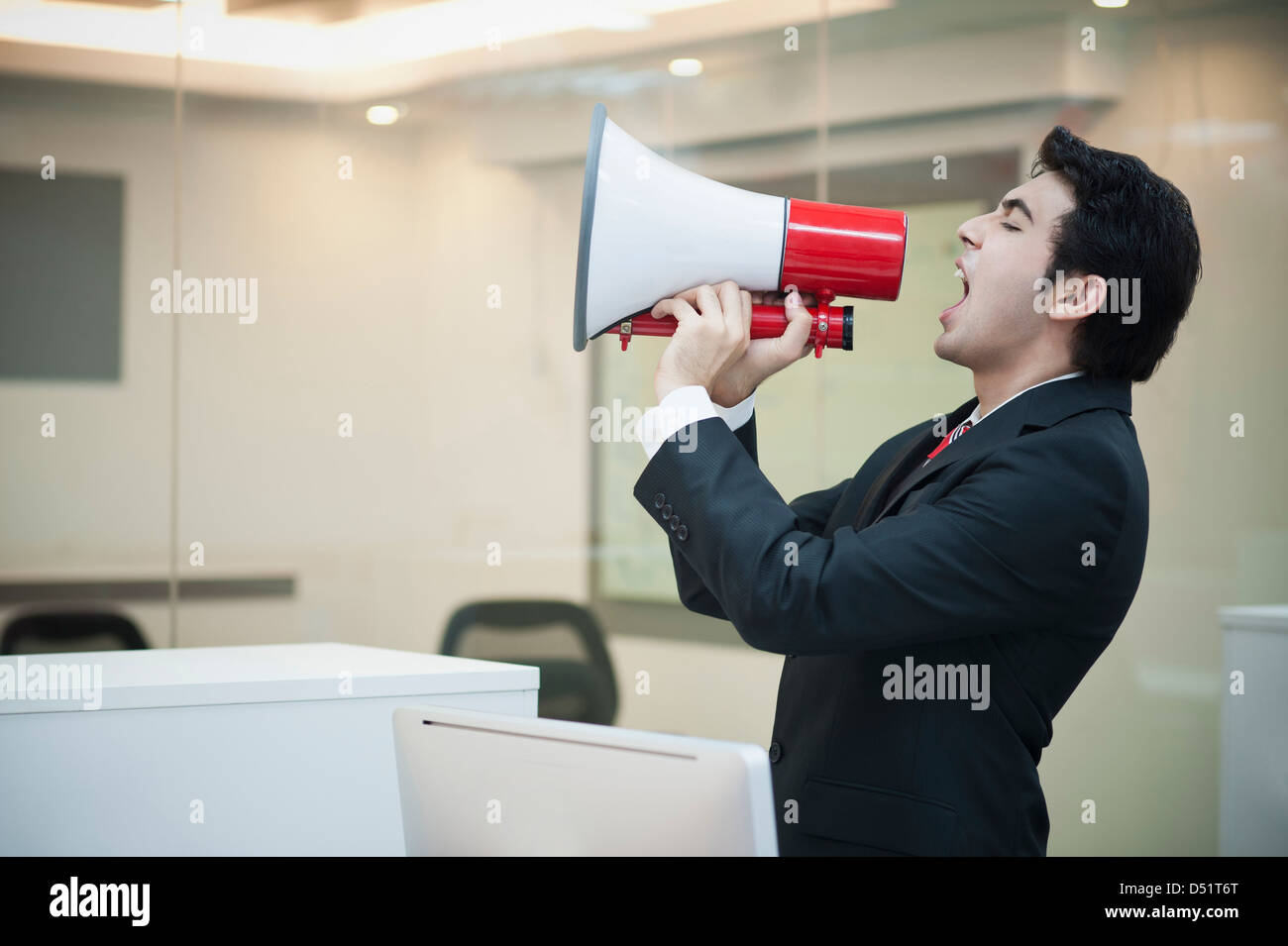 Businessman shouting into a bullhorn Stock Photo - Alamy