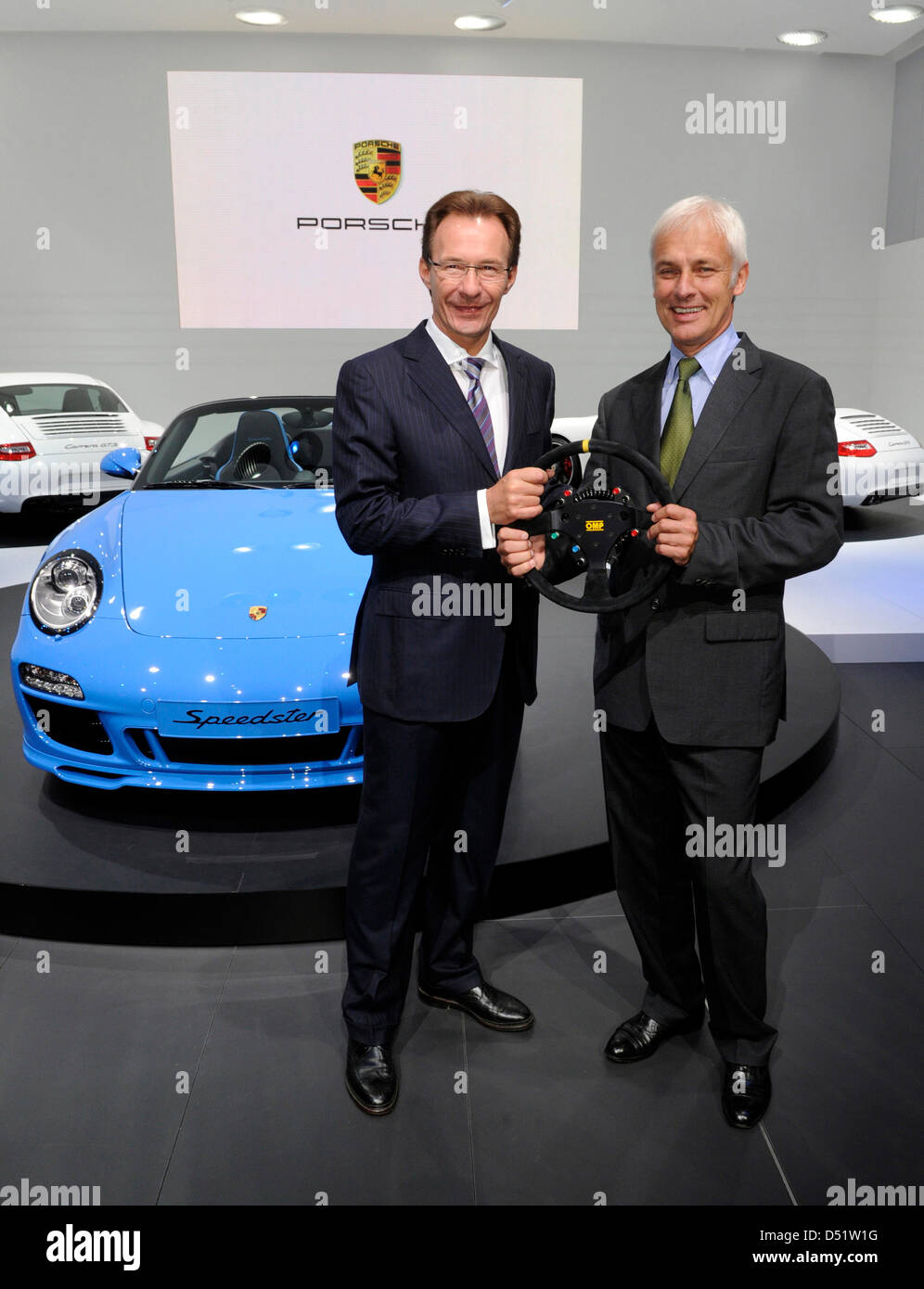 Michael Macht (L), chairman of Porsche, hands over a steering wheel to ...