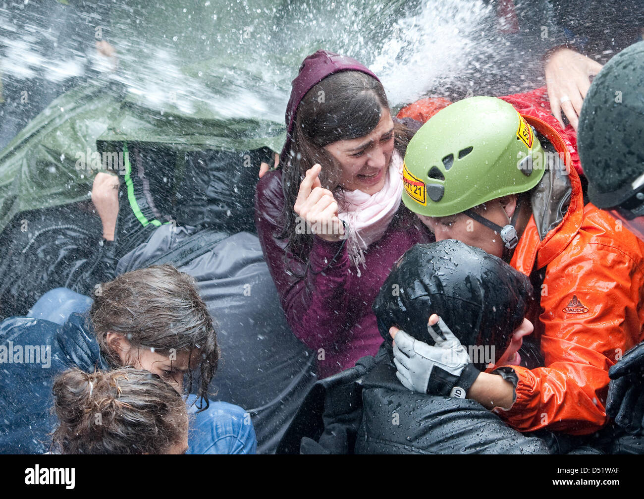 Police forces fire water cannons on people protesting against heavily ...
