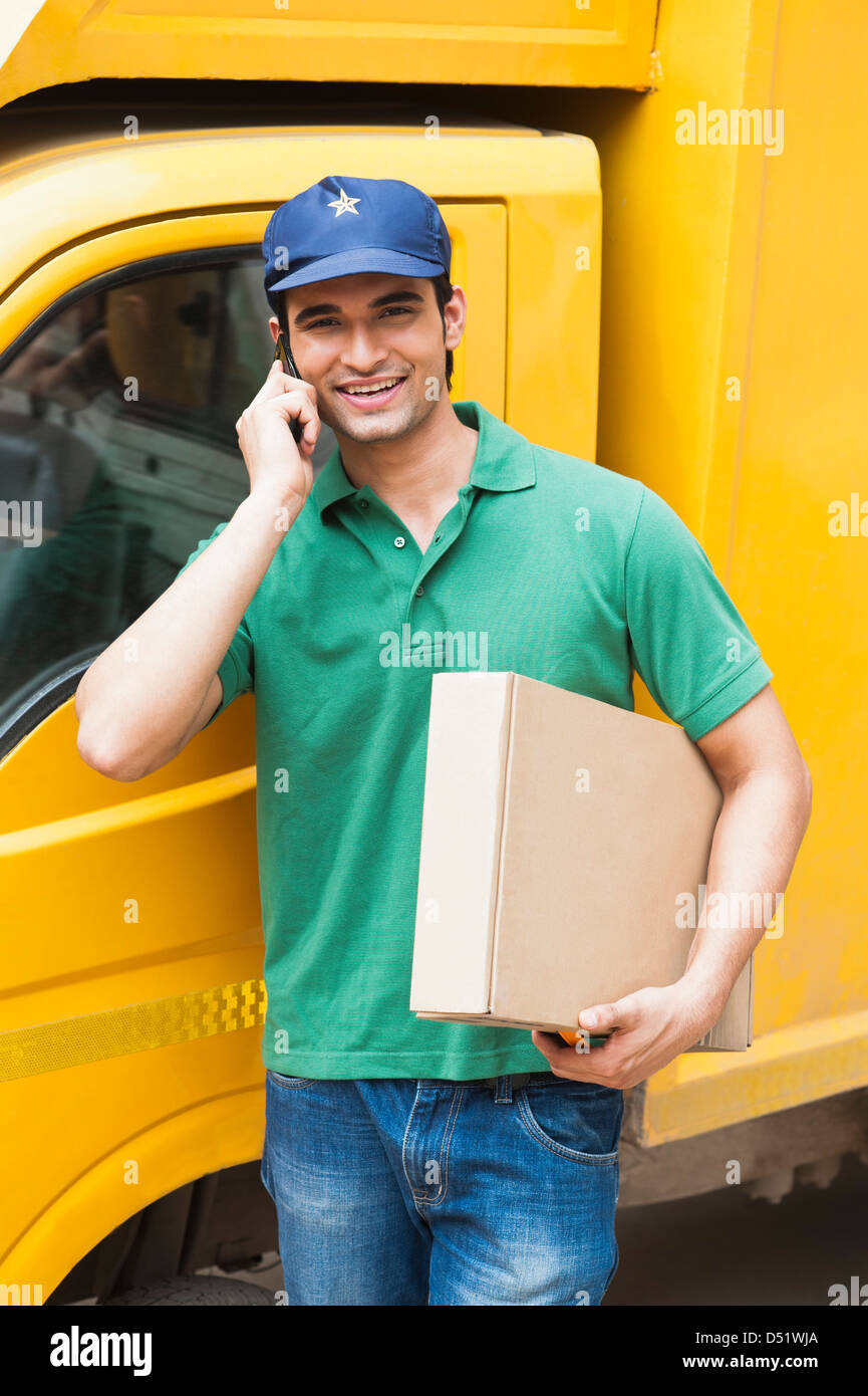 Delivery man talking on a mobile phone Stock Photo - Alamy