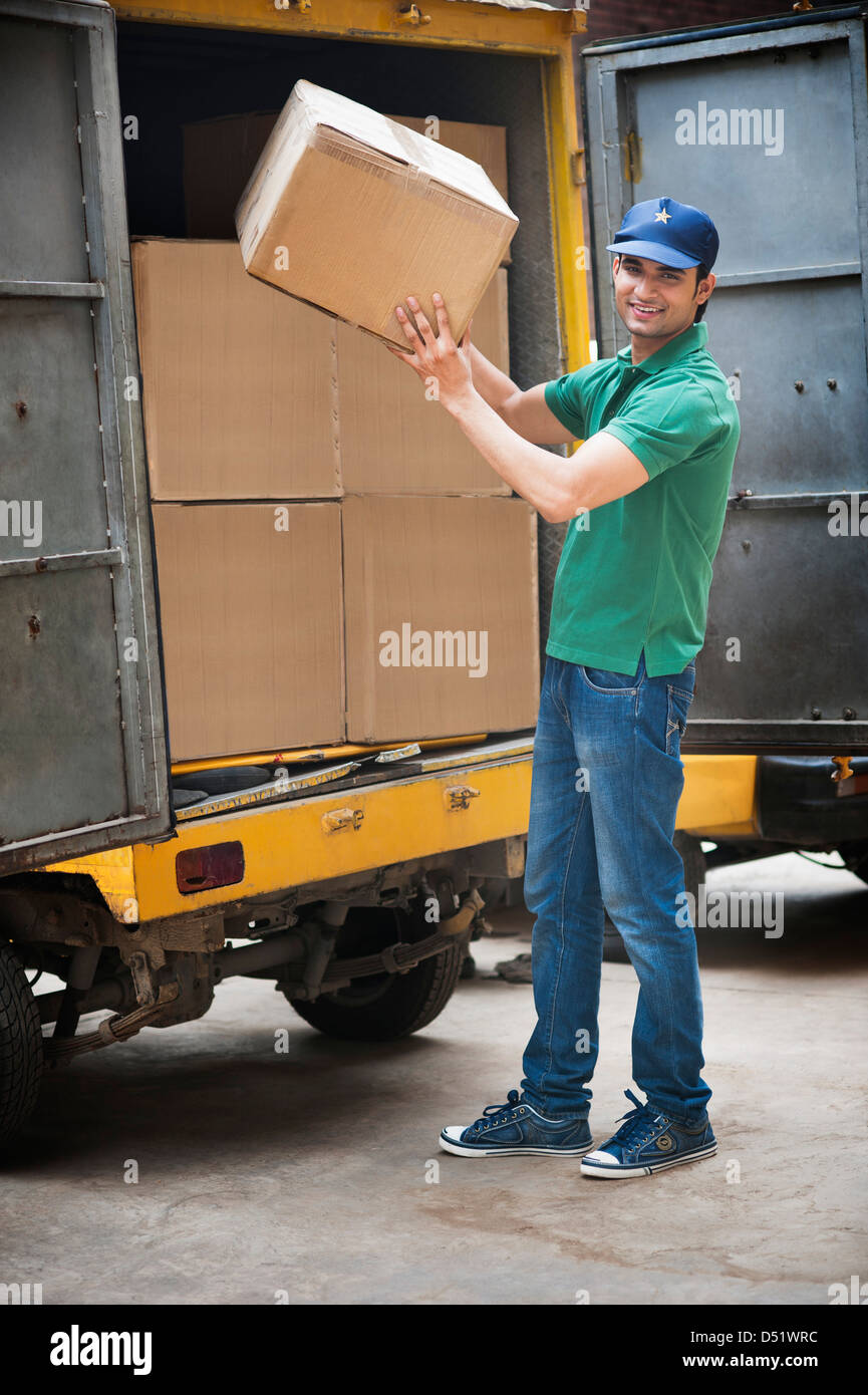 Delivery man unloading cardboard boxes from a van Stock Photo - Alamy