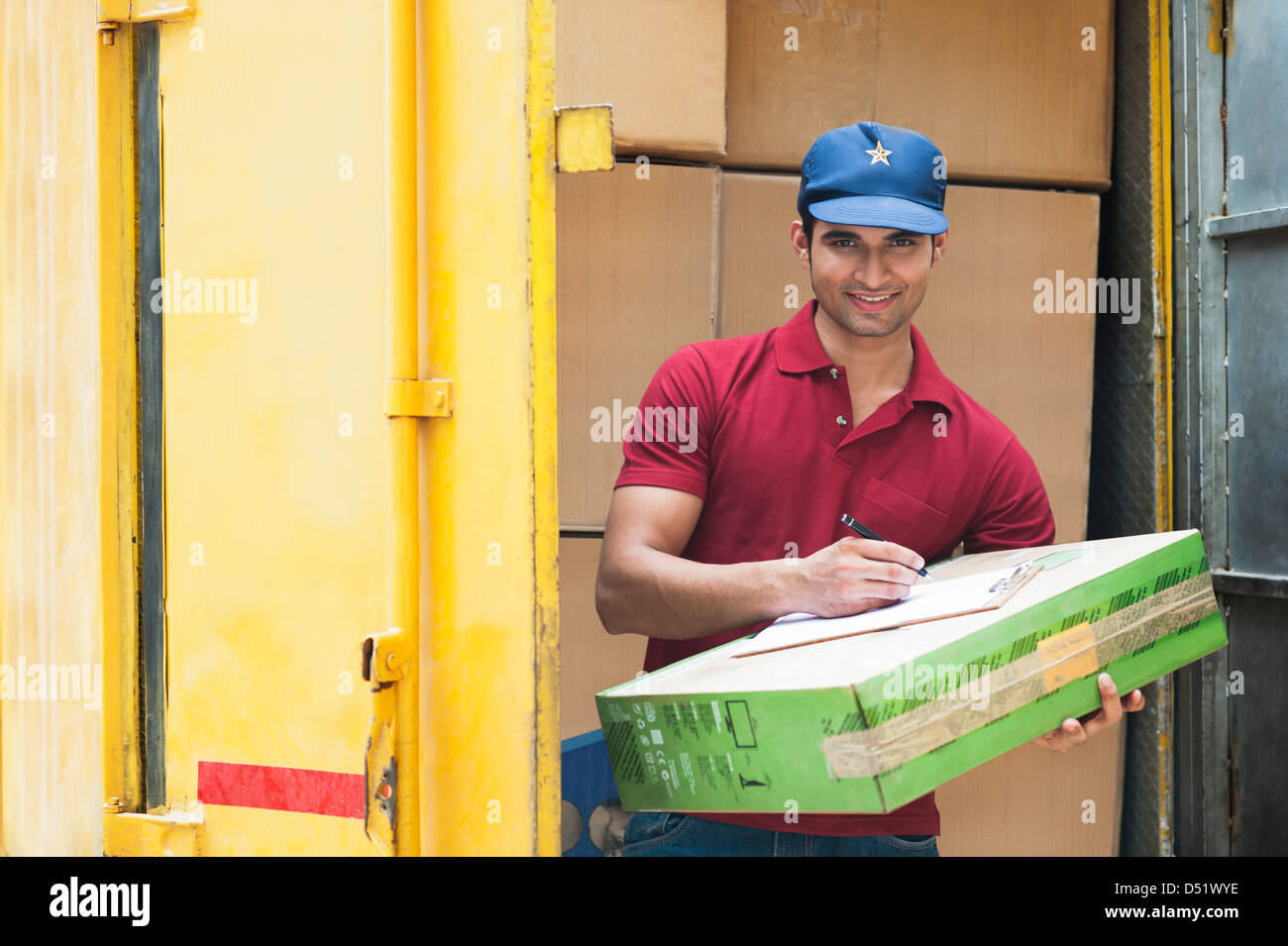 Delivery man signing a document Stock Photo - Alamy