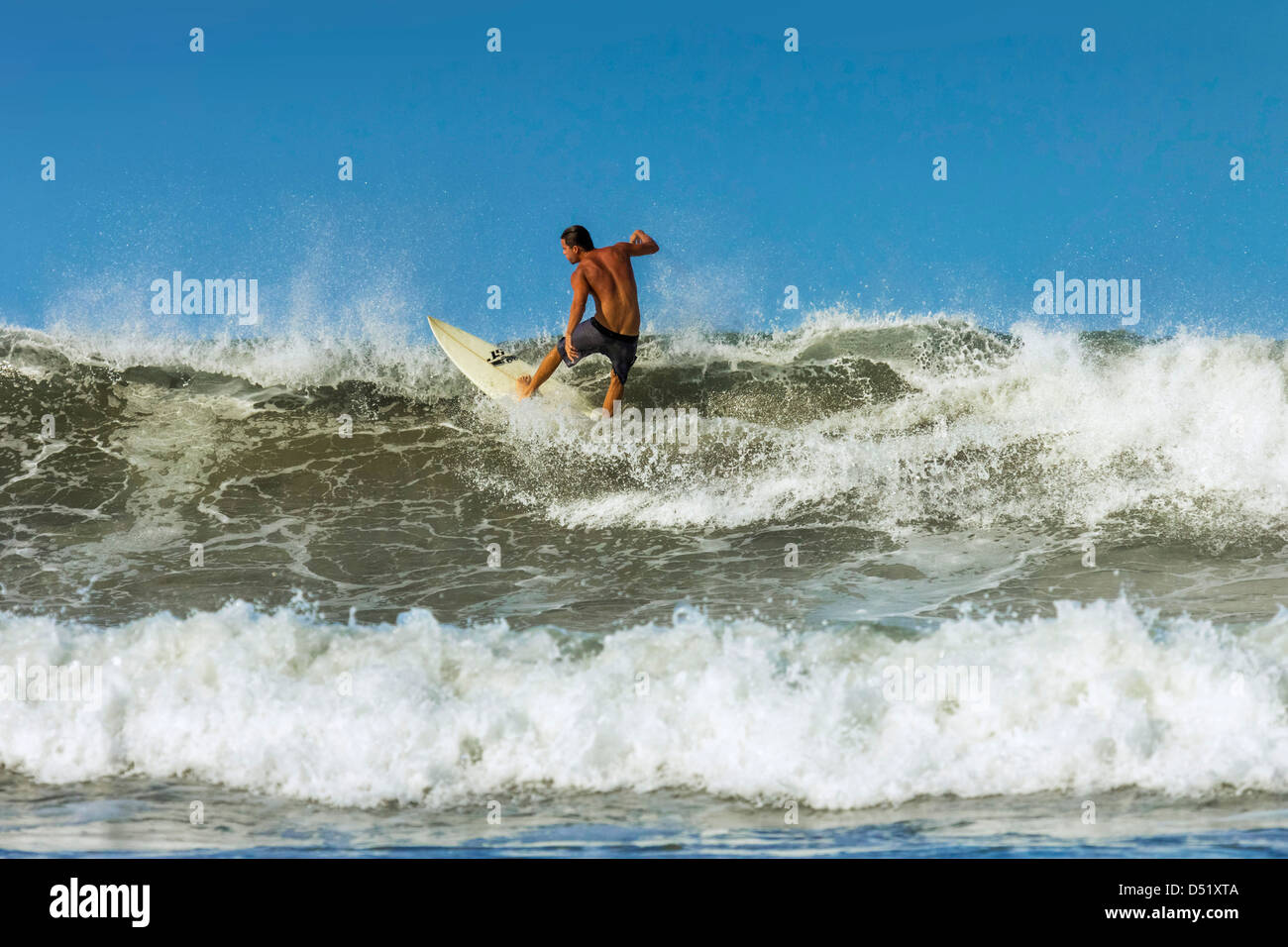 Surfer on shortboard riding wave at popular Playa Guiones surf beach ...