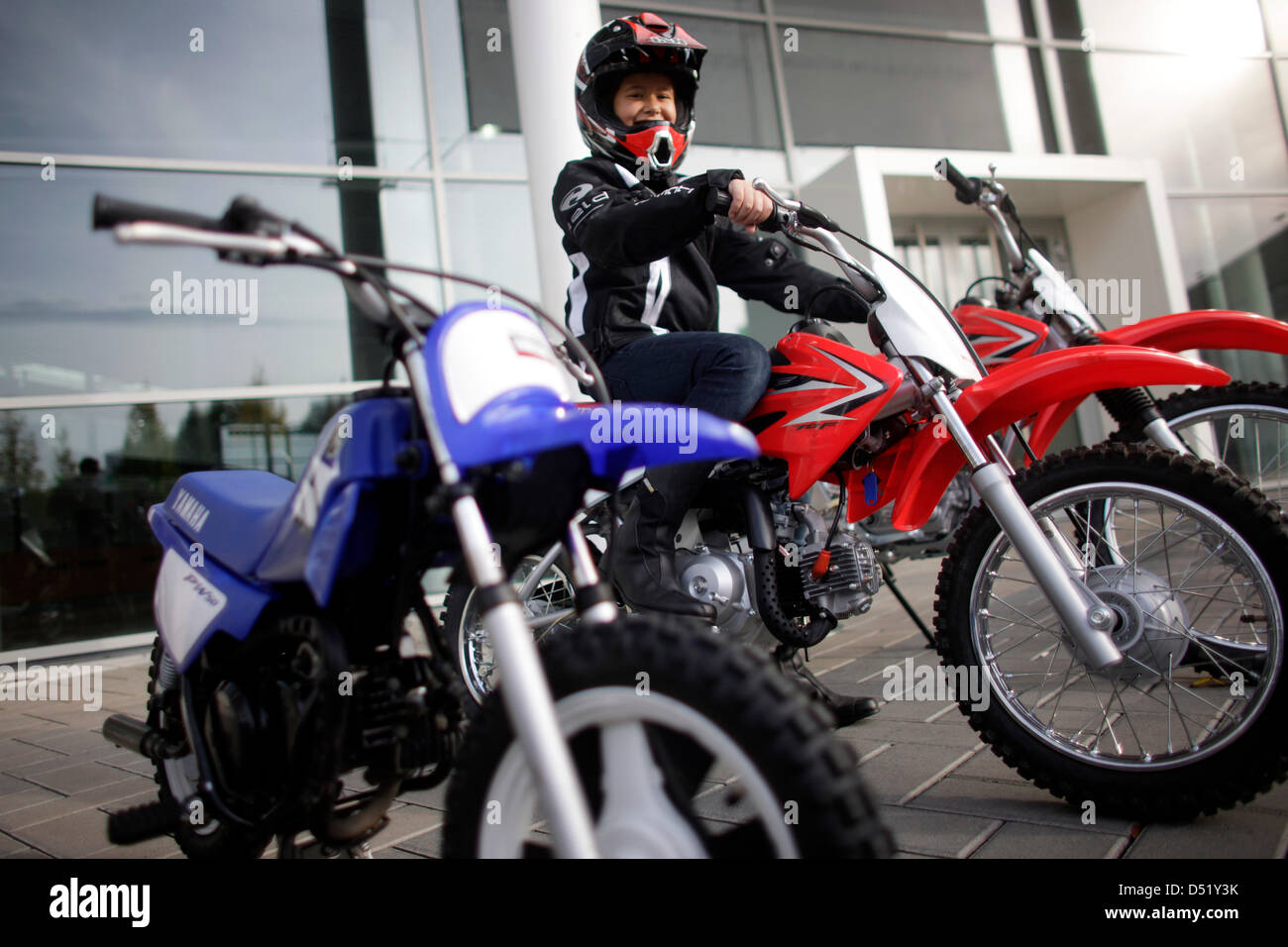 A child poses for a picture on a Honda children's motocross cycle at ...