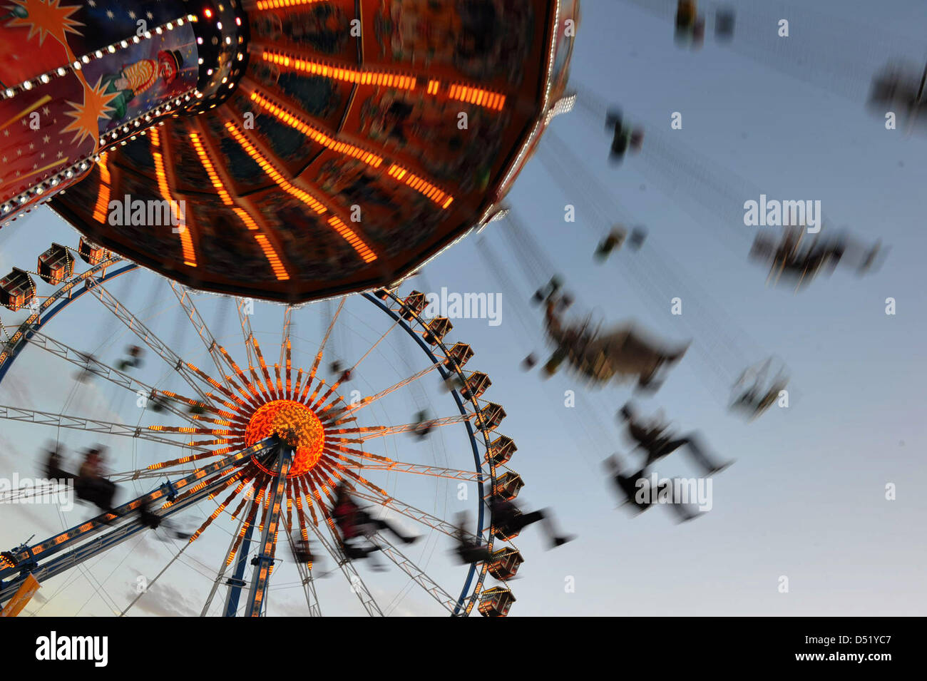 The sun shines through a big wheel at the Oktoberfest on it's last day ...
