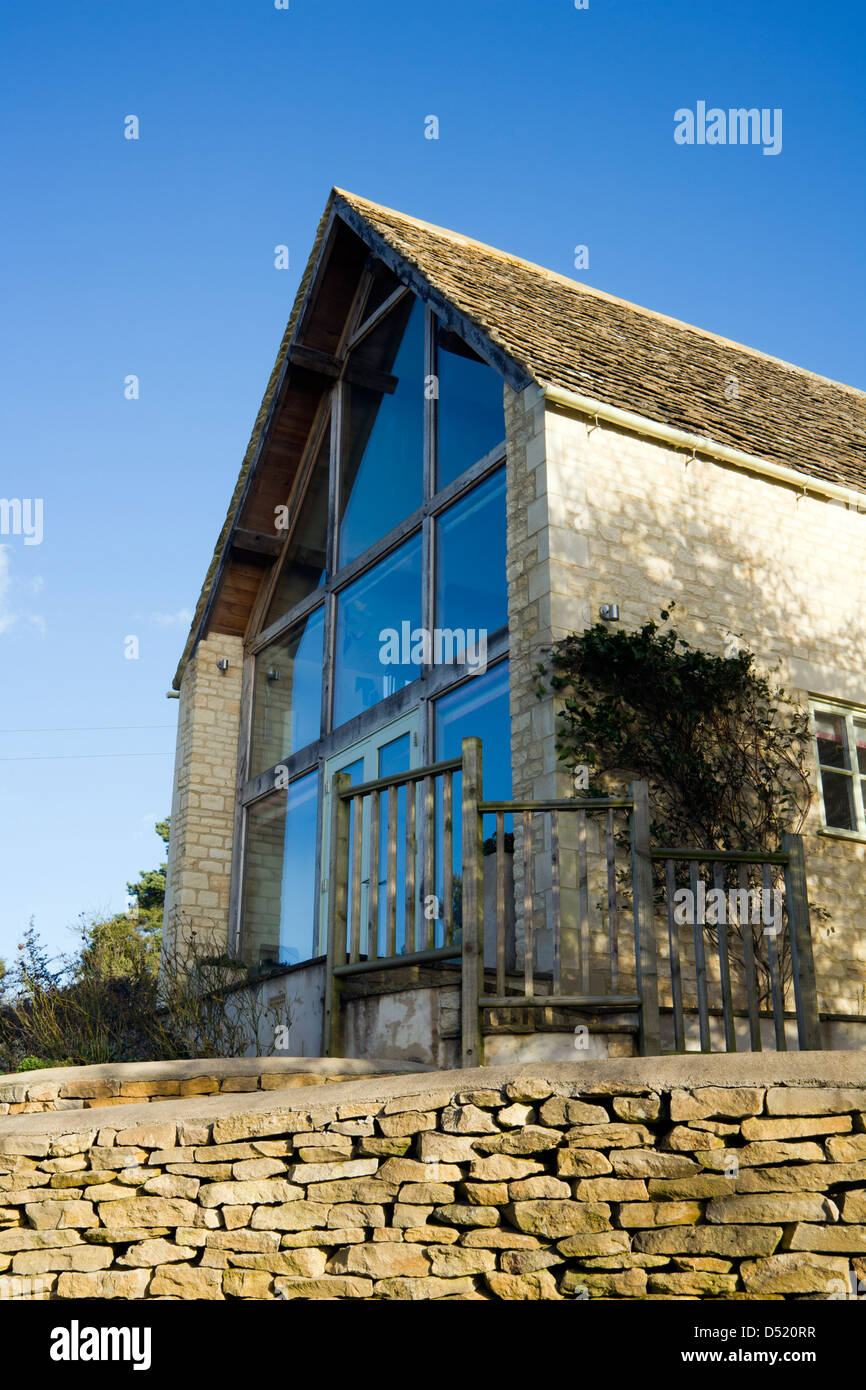 An modern oak framed glass wall in the gable end of an old cottage ...