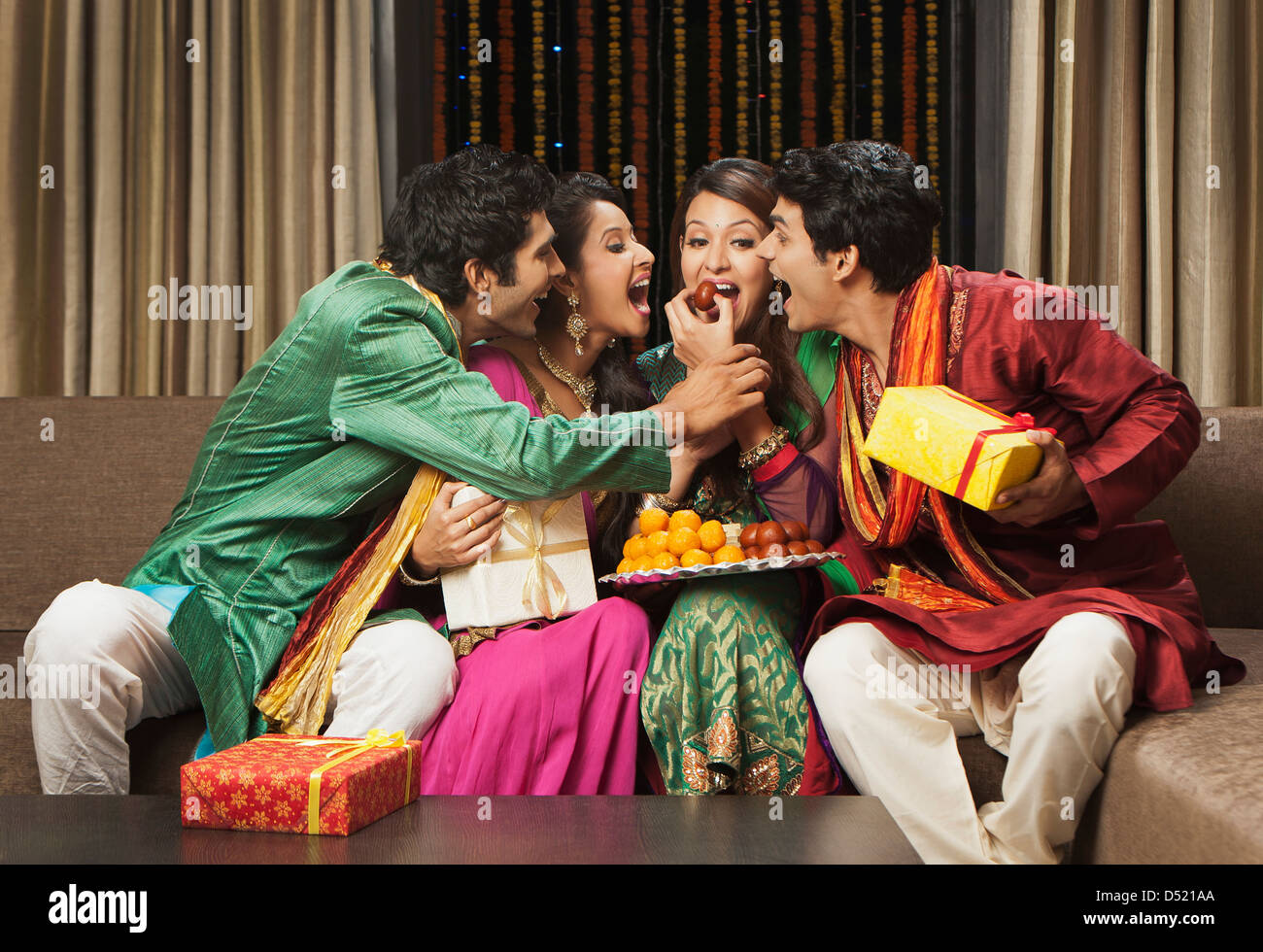 Friends eating sweets on Diwali Stock Photo - Alamy