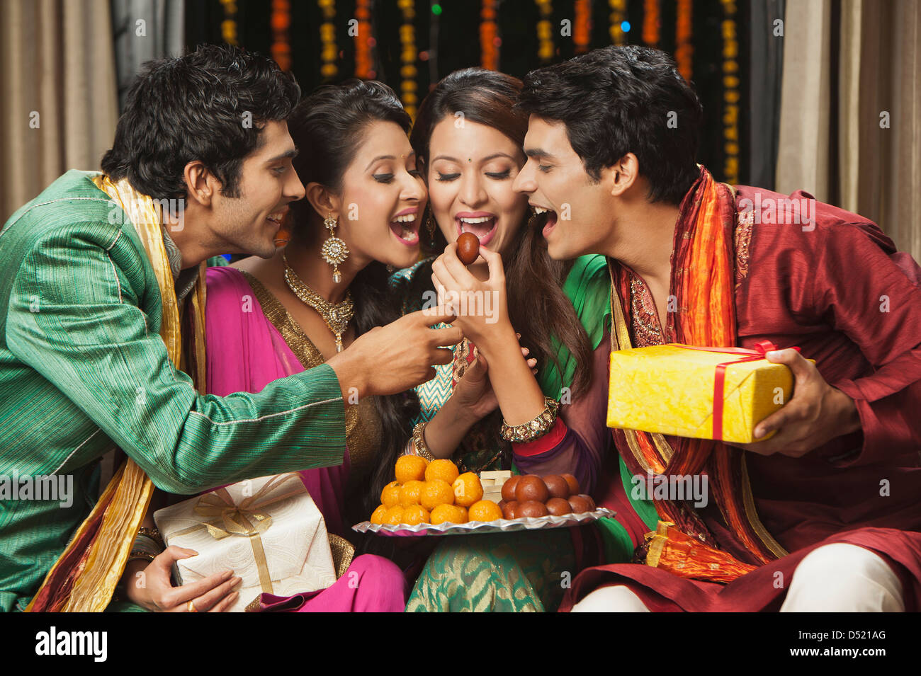 Friends eating sweets on Diwali Stock Photo - Alamy