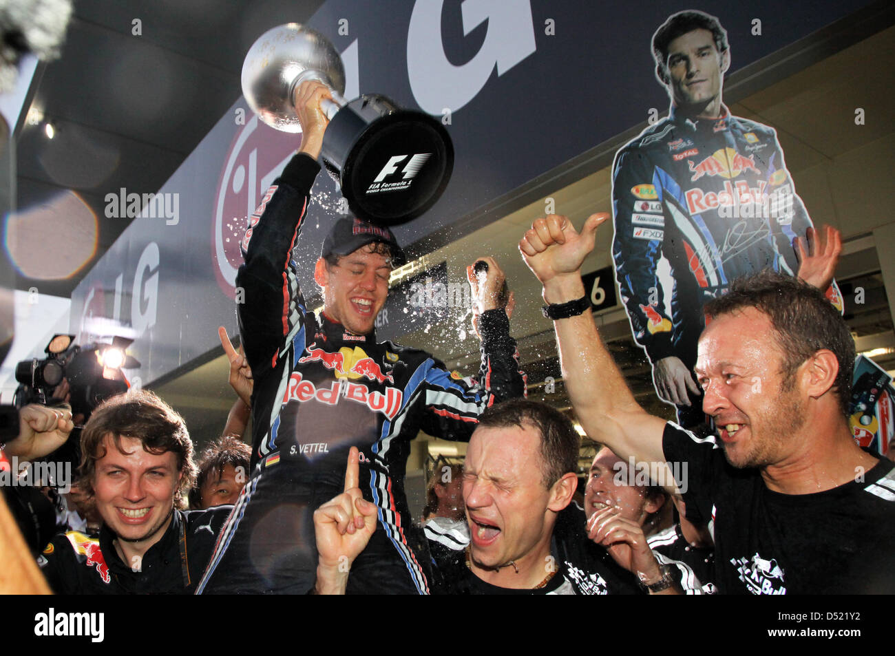 German formula one driver Sebastian Vettel (C) of Team Red Bull cheers ...