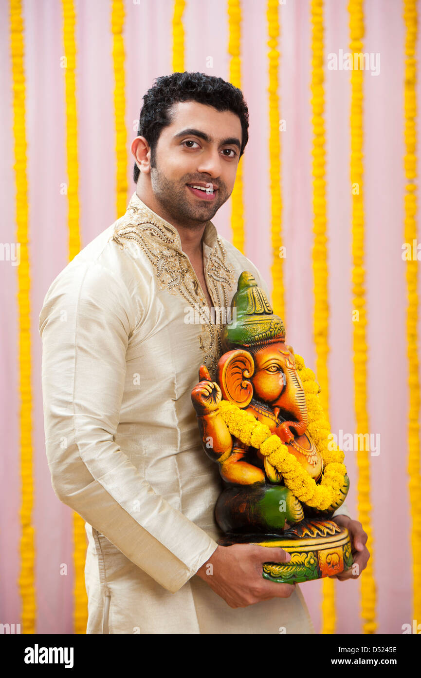 Maharashtrian man holding an Idol of Lord Ganesha during Ganesh ...