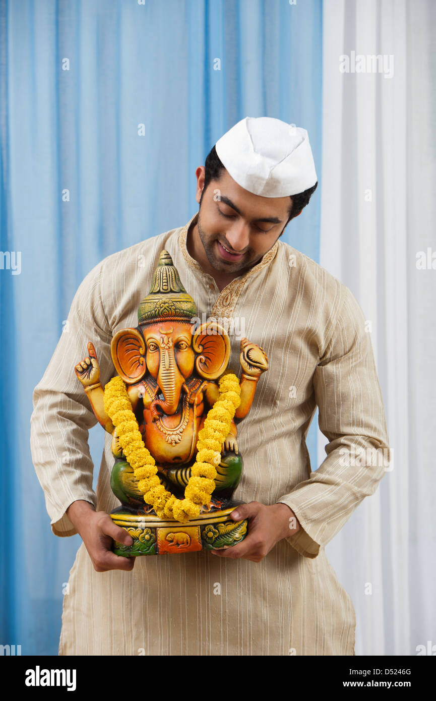 Maharashtrian man holding an Idol of Lord Ganesha during Ganesh ...
