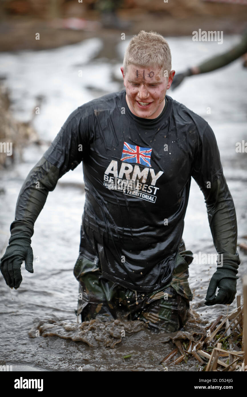 An Army recruit or soldier on a tough exercise wading through deep ...