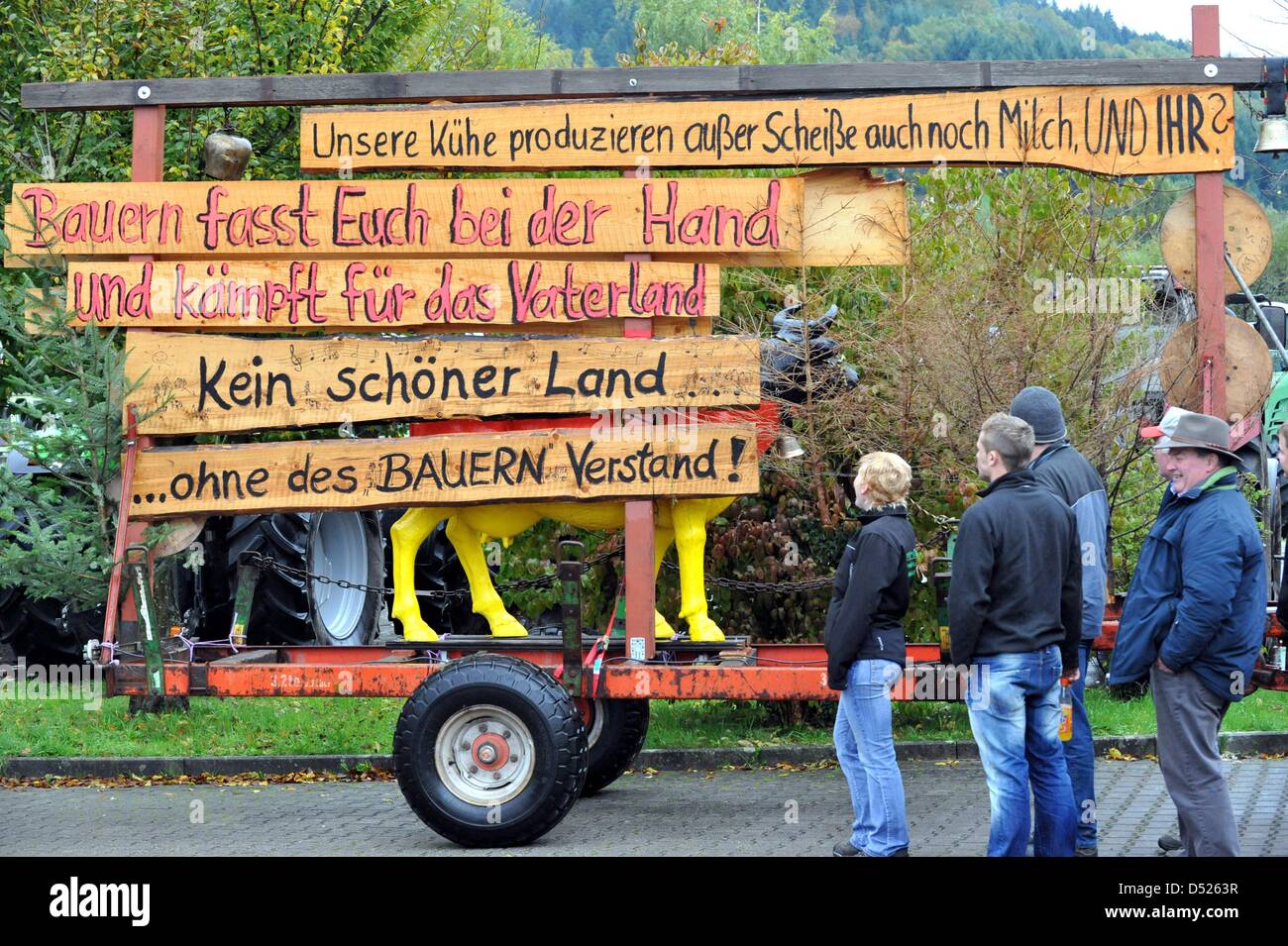 Dairy farmers stand in front of a trailer covered with provocative ...