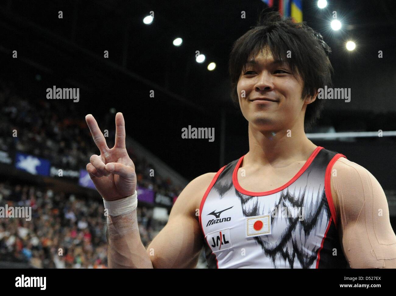Japanese gymnast Kohei Uchimura gives people a victory signal after the ...
