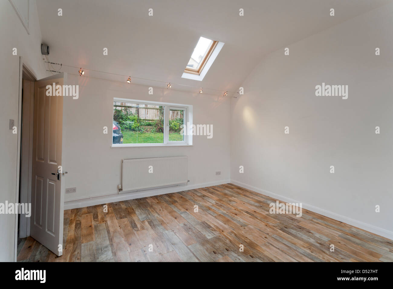 A large new unoccupied white painted high ceilinged empty room with ...