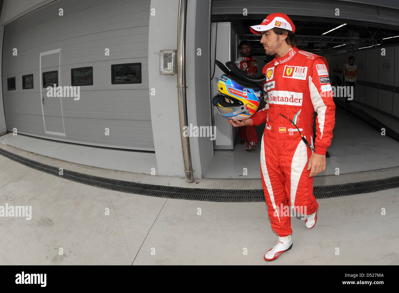 Spanish driver Fernando Alonso of Ferrari walks through the pit lane ...