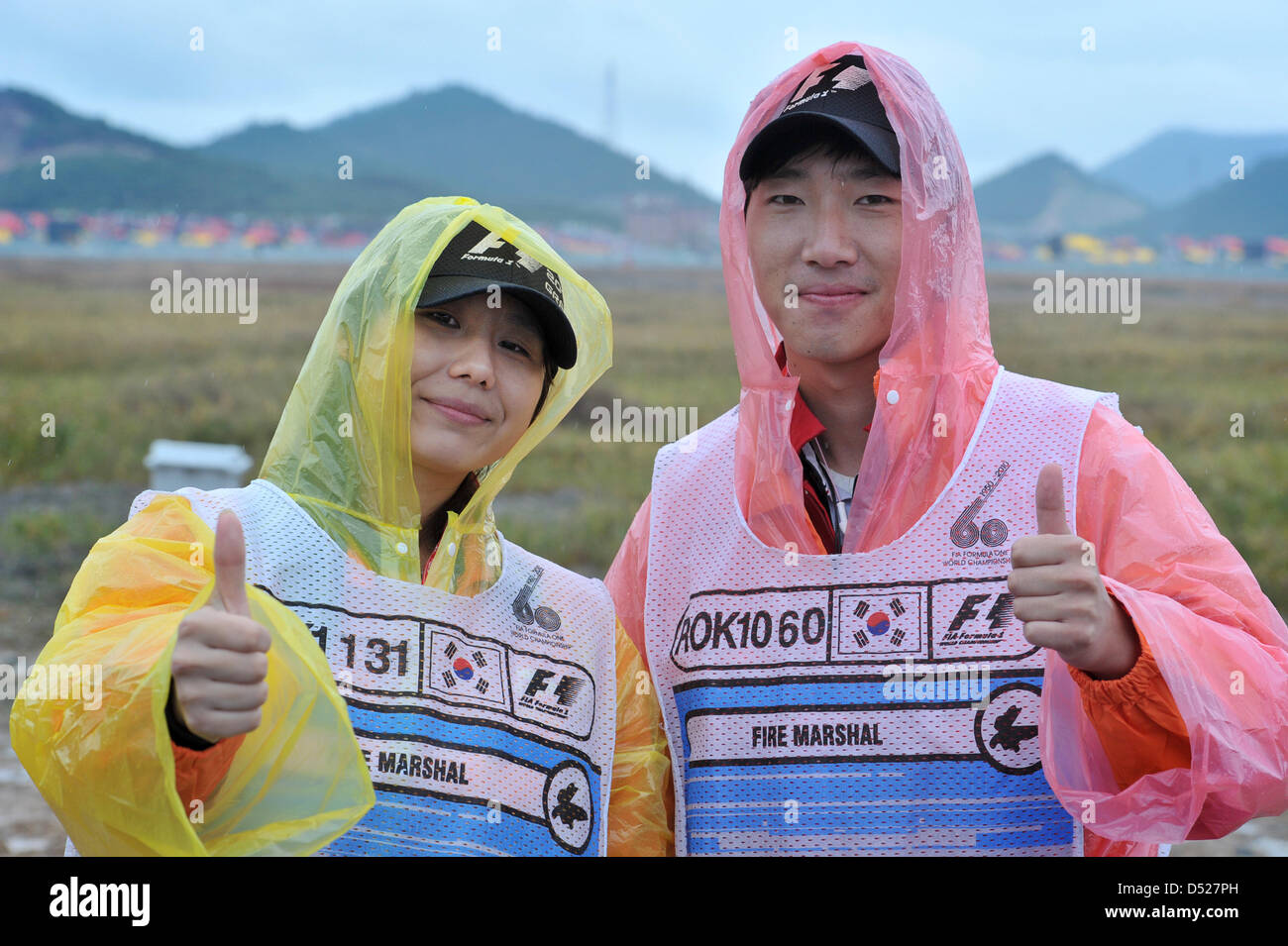 Korean track marshals give thumbs up in the pouring rain ahead of the ...