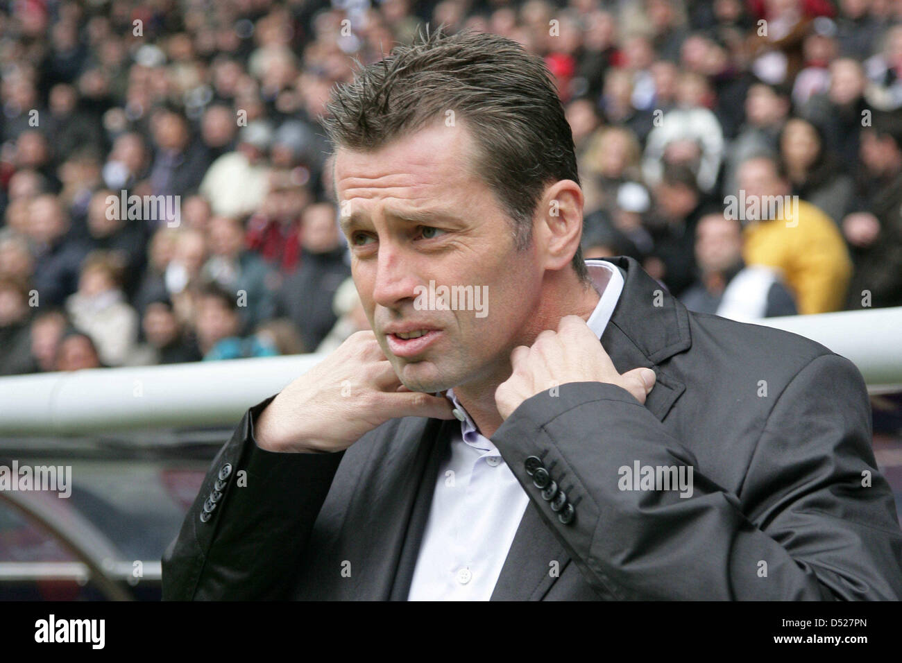 Coach Michael Skibbe of Frankfurt straightens his collar during a ...