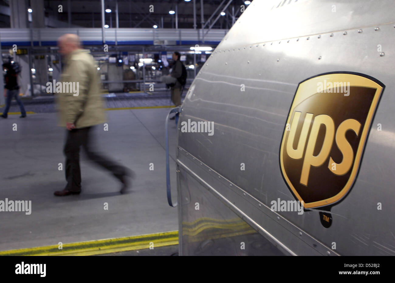 An employee of UPS walks past containers with air cargo at the cargo ...