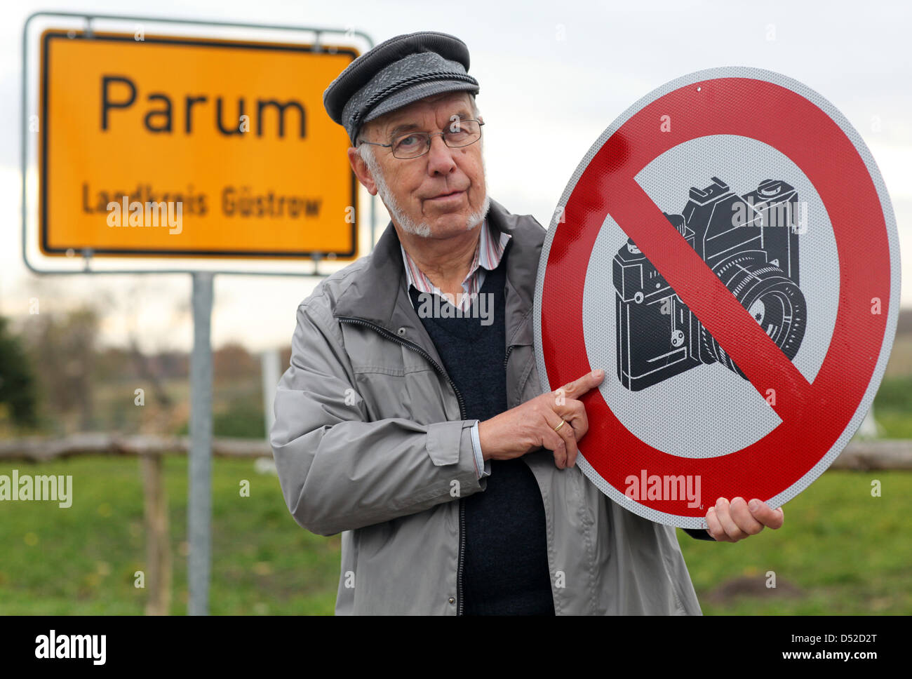 A Parum resident holds up a sign with a crossed-out camera in Parum ...
