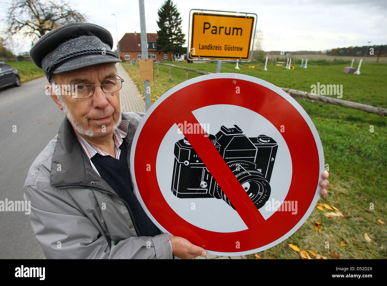 A Parum resident holds up a sign with a crossed-out camera in Parum ...